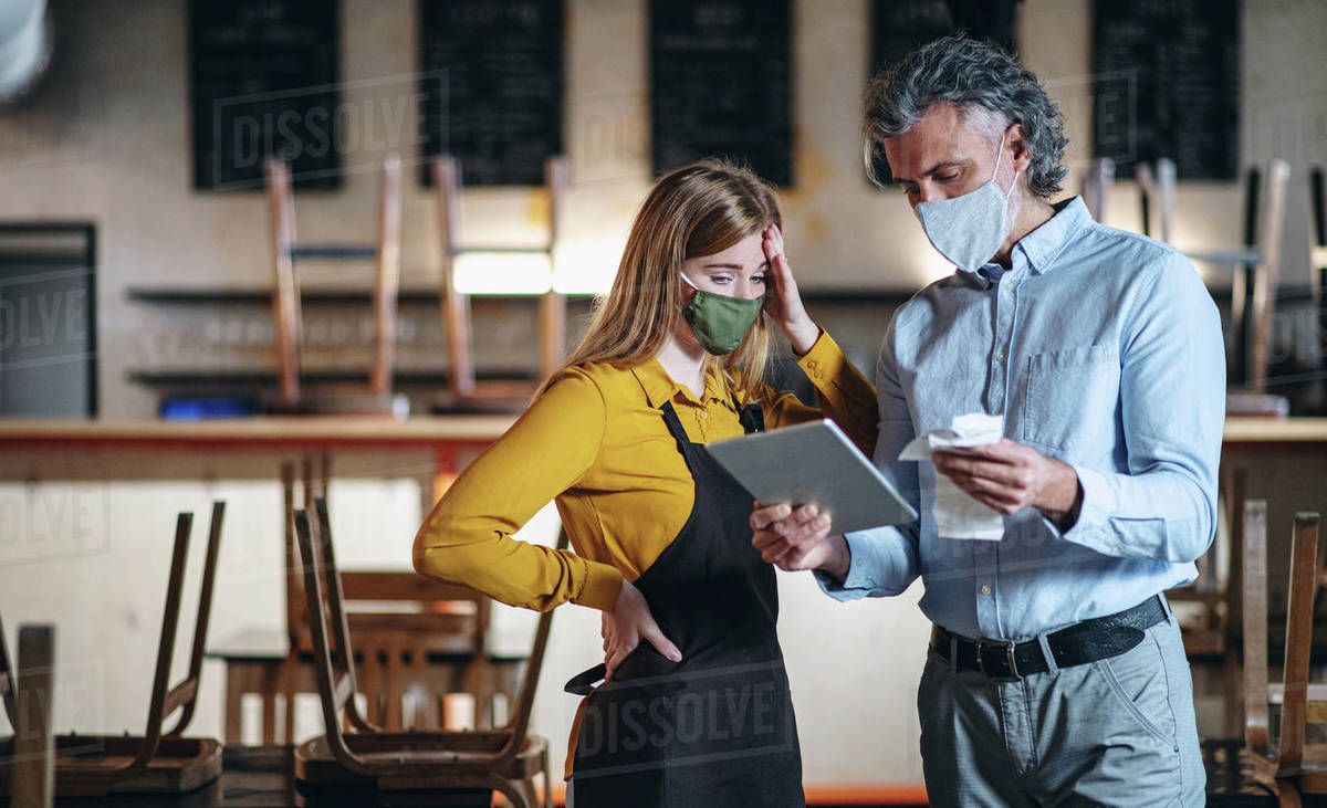 Frustrated owner with waitress talking in closed cafe, small business ...