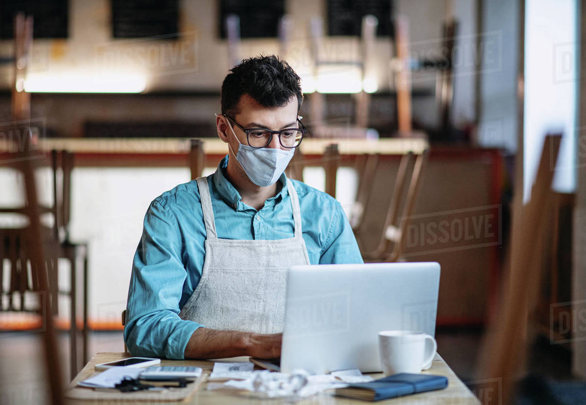 Frustrated owner sitting at table in closed cafe or coffee shop, small ...