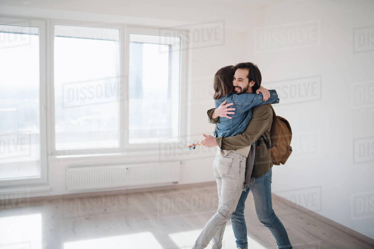 Happy young couple owners hugging in new flat, moving in, new home and ...