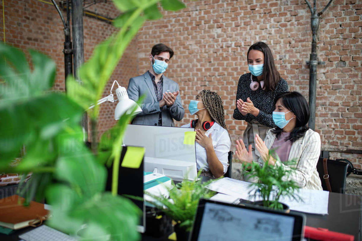 Group of young and old architects feeling joyful at desk in office ...