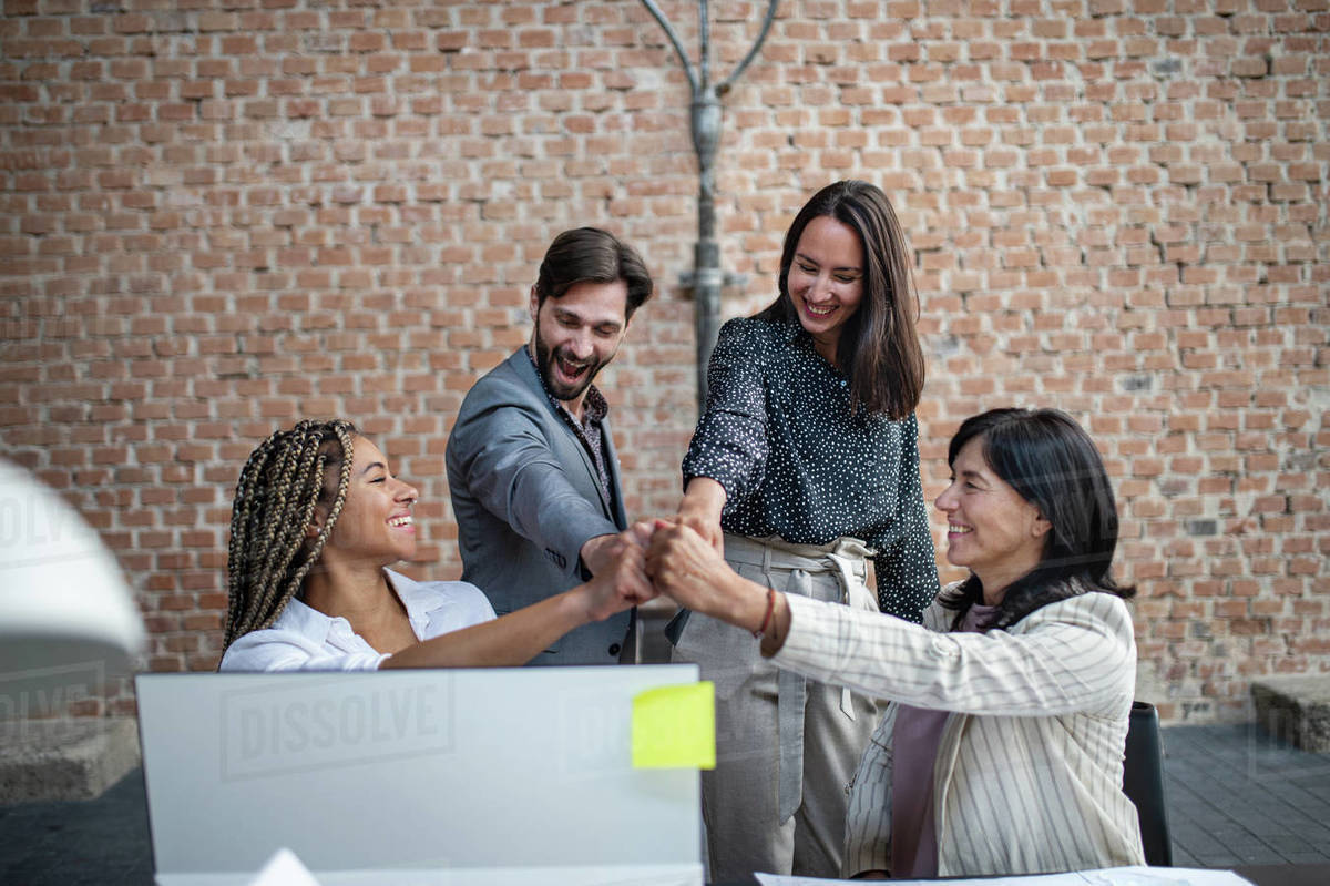 Cheerful young and old businesspeople celebrating success in a office ...