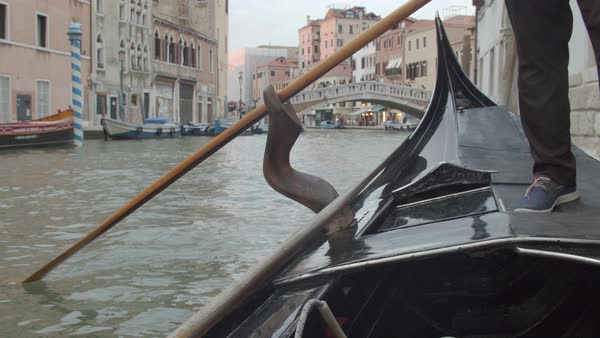 Medium shot of a man rowing gondola in canal, Venice, Italy, Europe ...