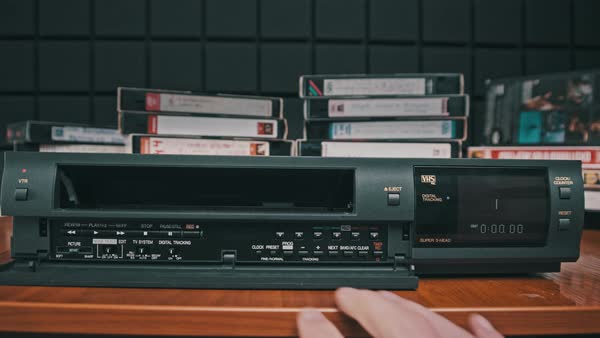 Insert VHS cassette into VCR and push play button. Black vintage ...