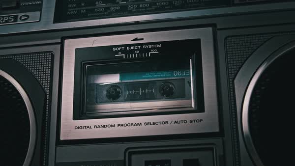 Audiocassette rotates in deck of old tape recorder. Audio cassette with ...