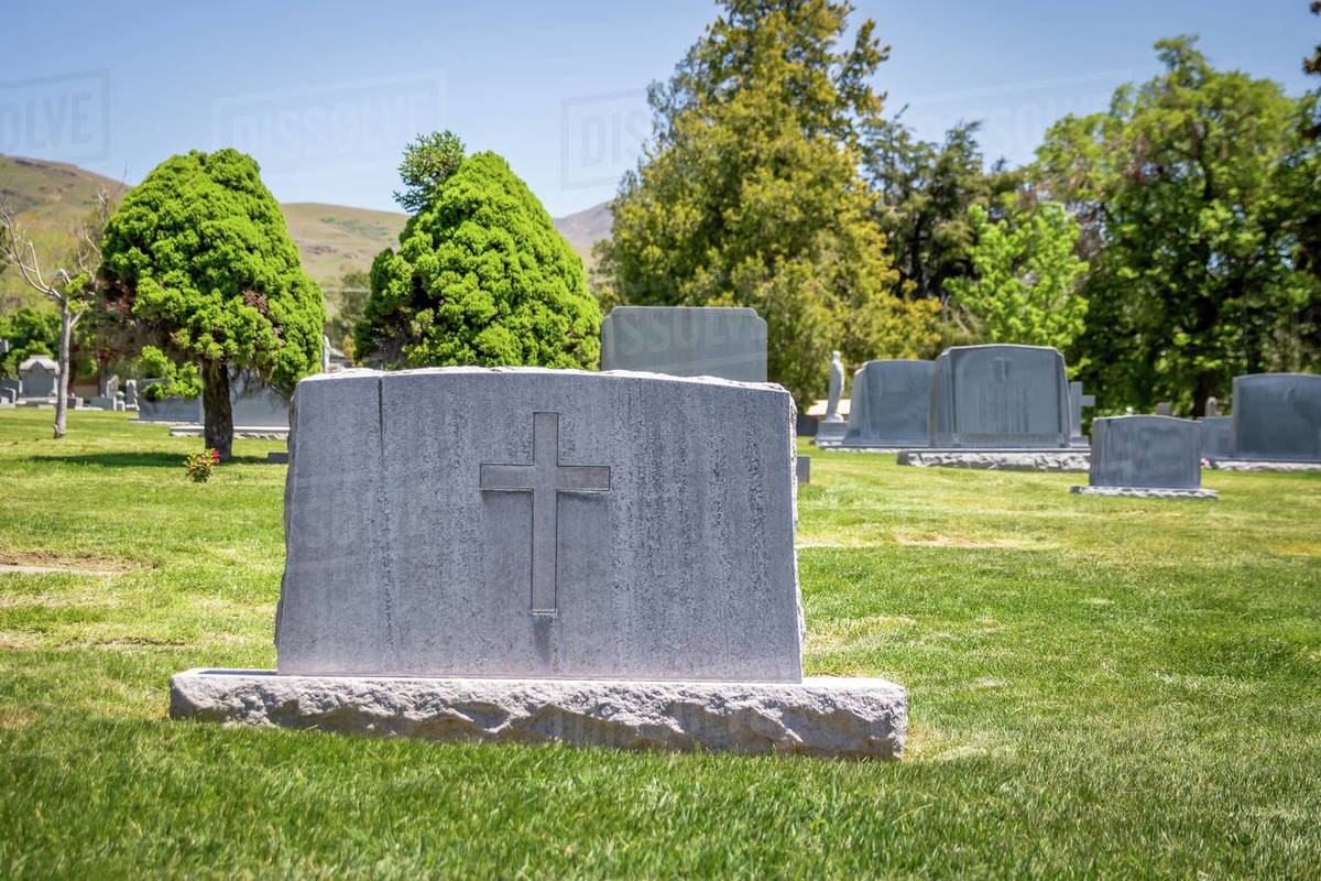 Granite headstone decorated with a large Christian cross at a cemetery ...