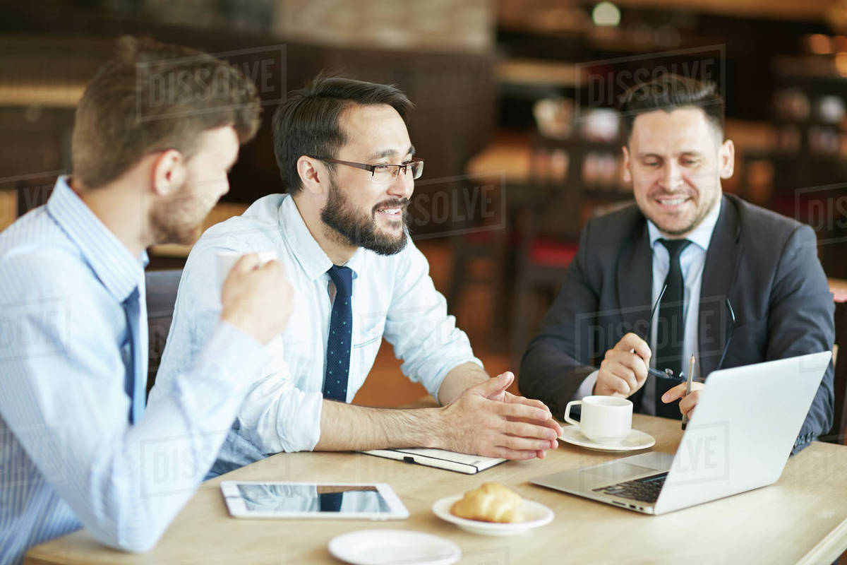 Successful employees spending time in cafe by cup of coffee and ...