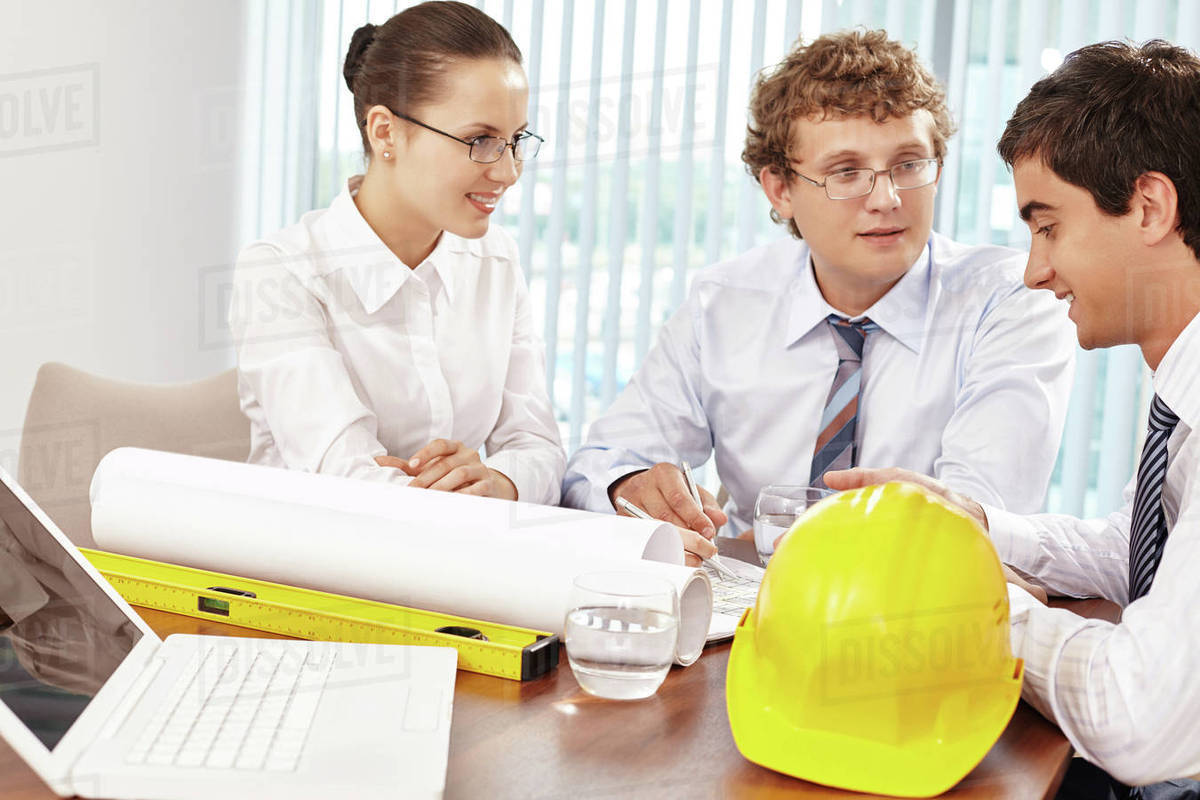 Group of young engineers planning business plan together at the table ...