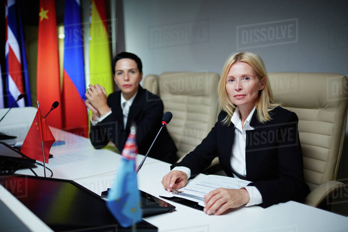 Two female politicians sitting at political conference - Royalty-free ...