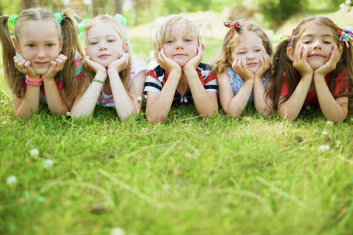 Group of friendly kids lying on the lawn - Royalty-free Stock Photo ...