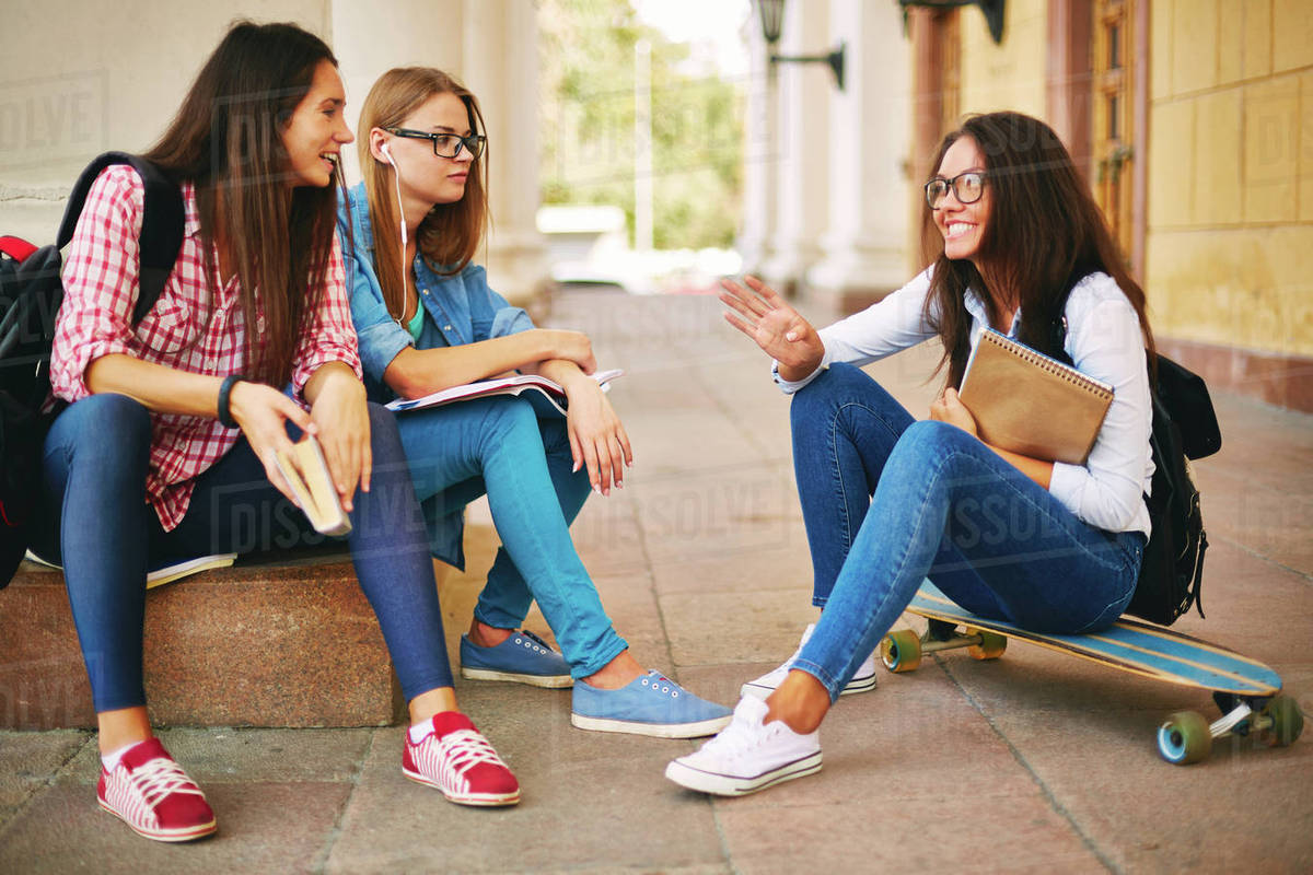 Three girls sitting and chatting - Stock Photo - Dissolve