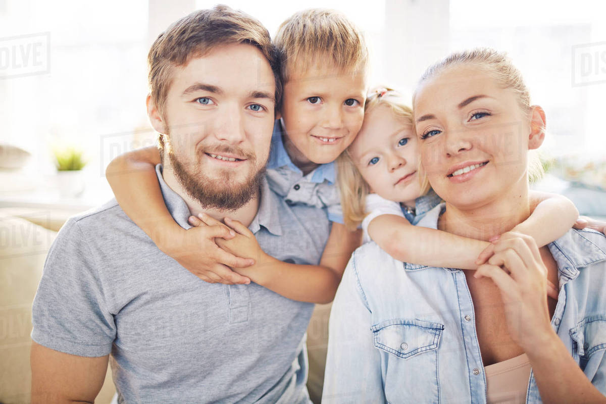 Young family with two kids looking at camera - Royalty-free Stock Photo ...