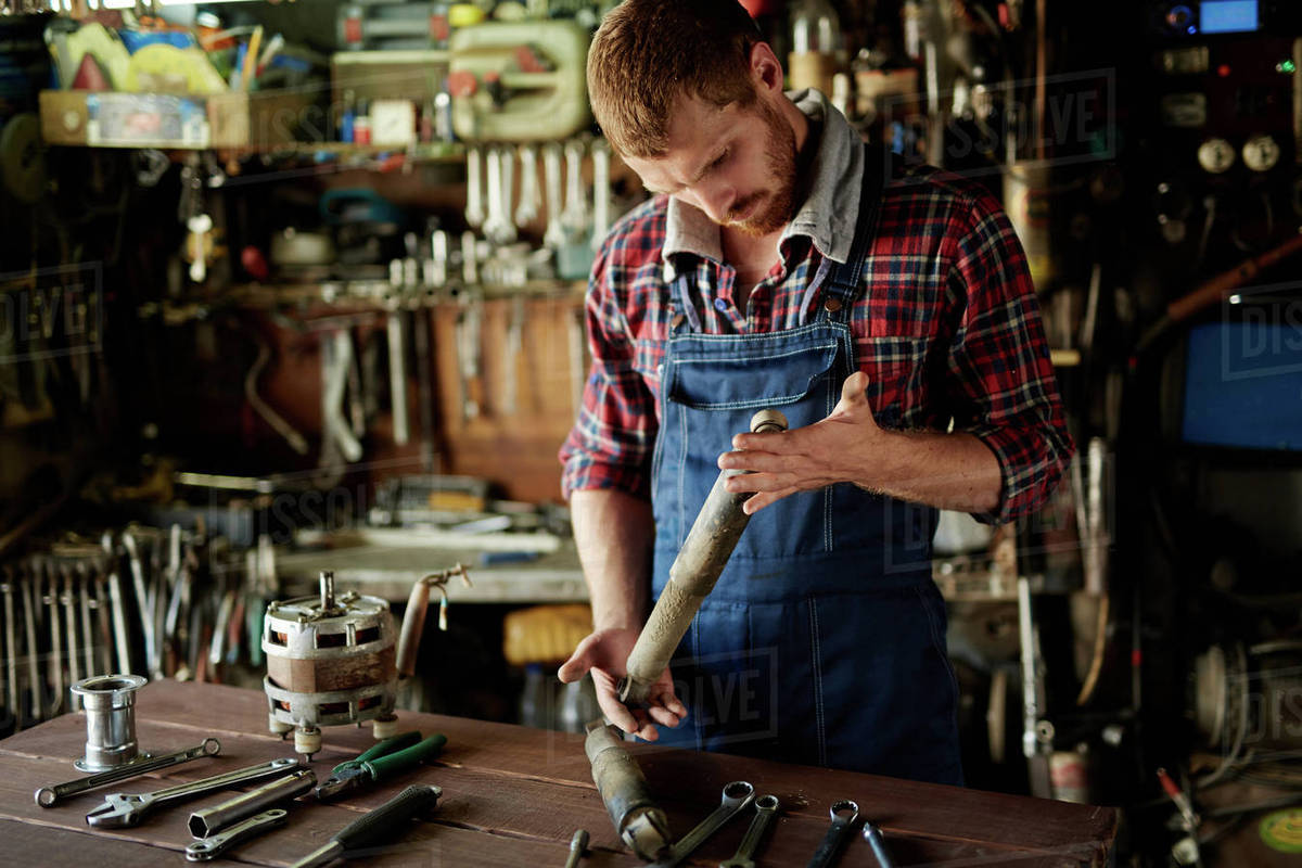 Mechanic busy with his work in workshop - Royalty-free Stock Photo ...
