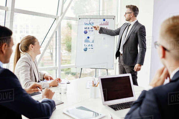 Businessman presenting to colleagues at a meeting - Stock Photo - Dissolve