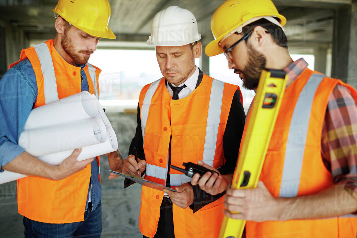 Team of constructors in uniform making plan of further rwork - Royalty ...