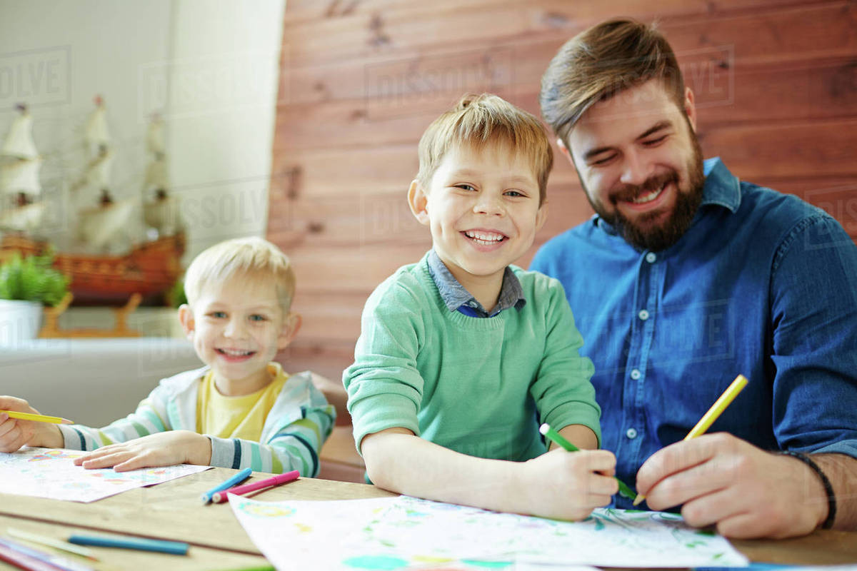 Happy man and his two sons drawing at home - Stock Photo - Dissolve