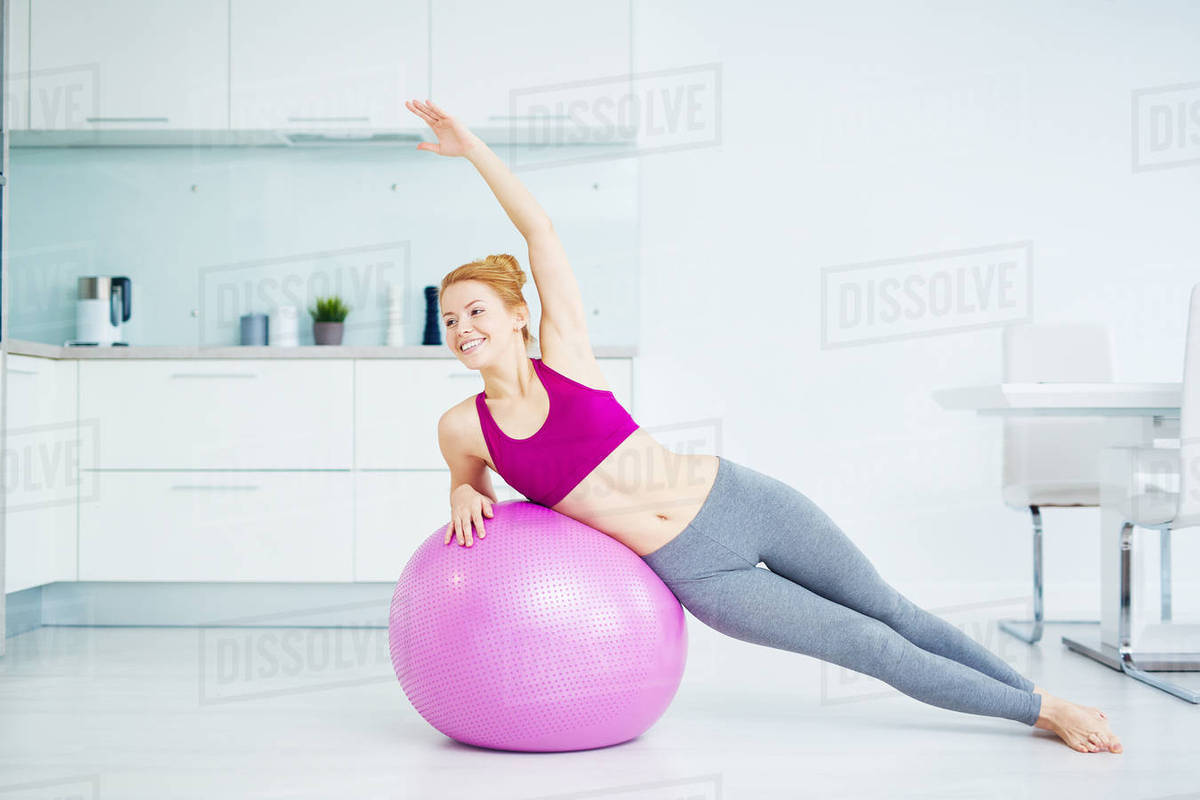 Happy active woman training with fitball in the kitchen - Royalty-free ...