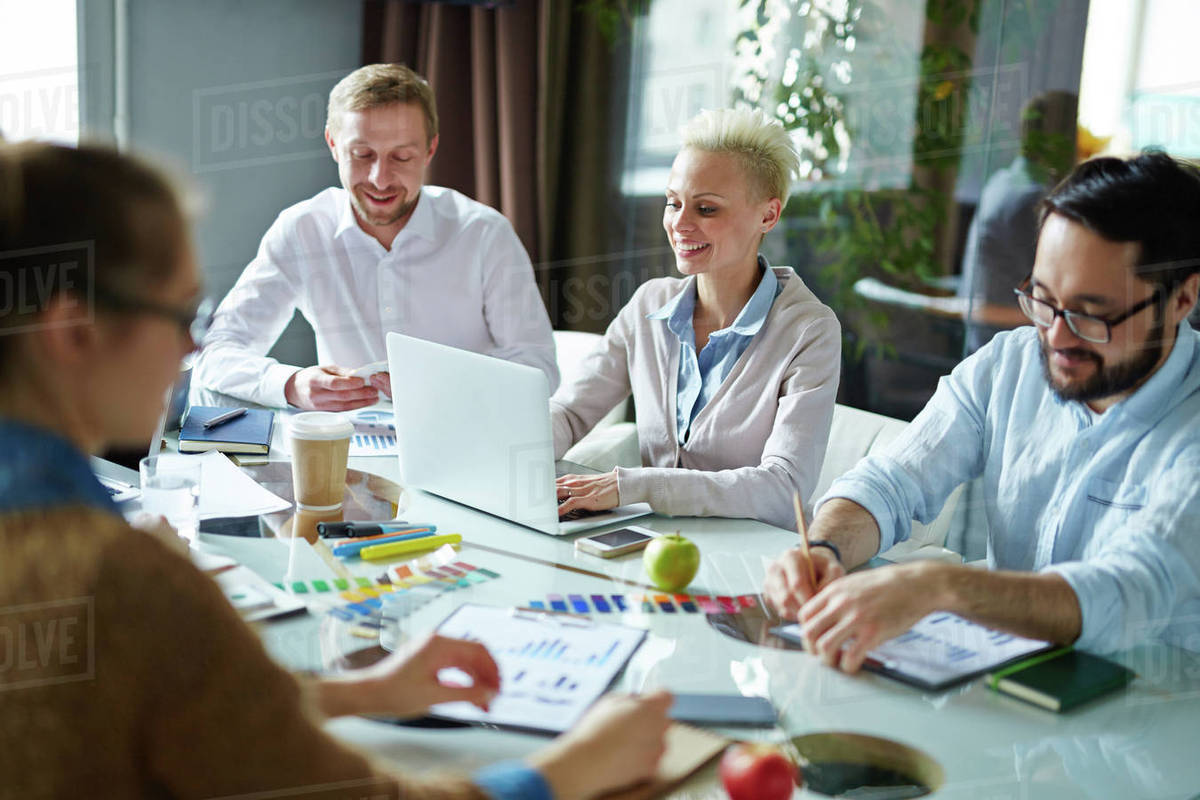 Group of business partners working by table at meeting - Royalty-free ...