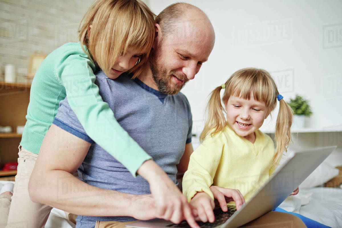 Girls and their father typing on laptop keypad - Royalty-free Stock ...