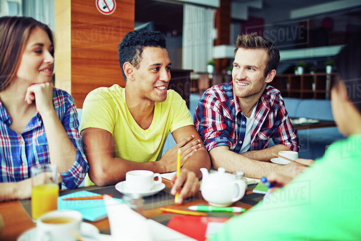 Students talking in cafe after studies - Stock Photo - Dissolve