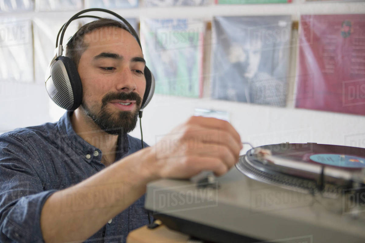 Young man listening to a record at a record store - Royalty-free Stock ...