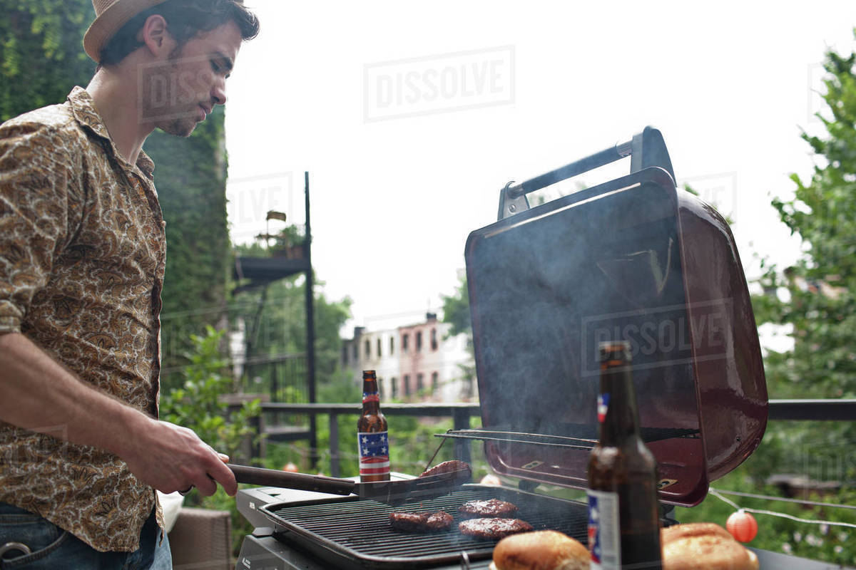 Young man barbecuing - Royalty-free Stock Photo | Dissolve
