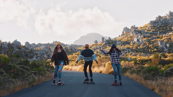 Happy diverse friends longboarding together riding skateboard cruising ...