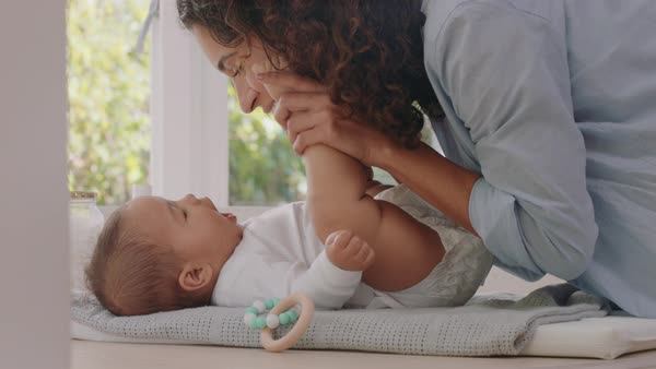 Happy mother caring for baby at home, loving mom nurturing child ...