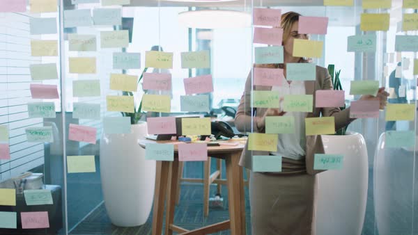 Beautiful business woman using sticky notes brainstorming ideas ...