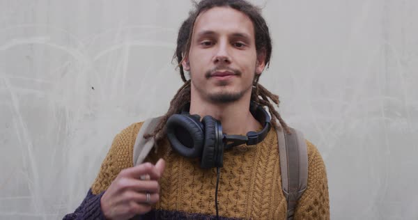 Portrait of confident young mixed race man with dreadlocks looking ...