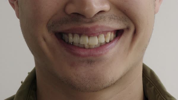 Close up young man lips smiling cheerful happy showing teeth dental ...