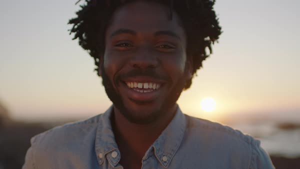 Close up portrait of young man laughing cheerfully while looking at ...