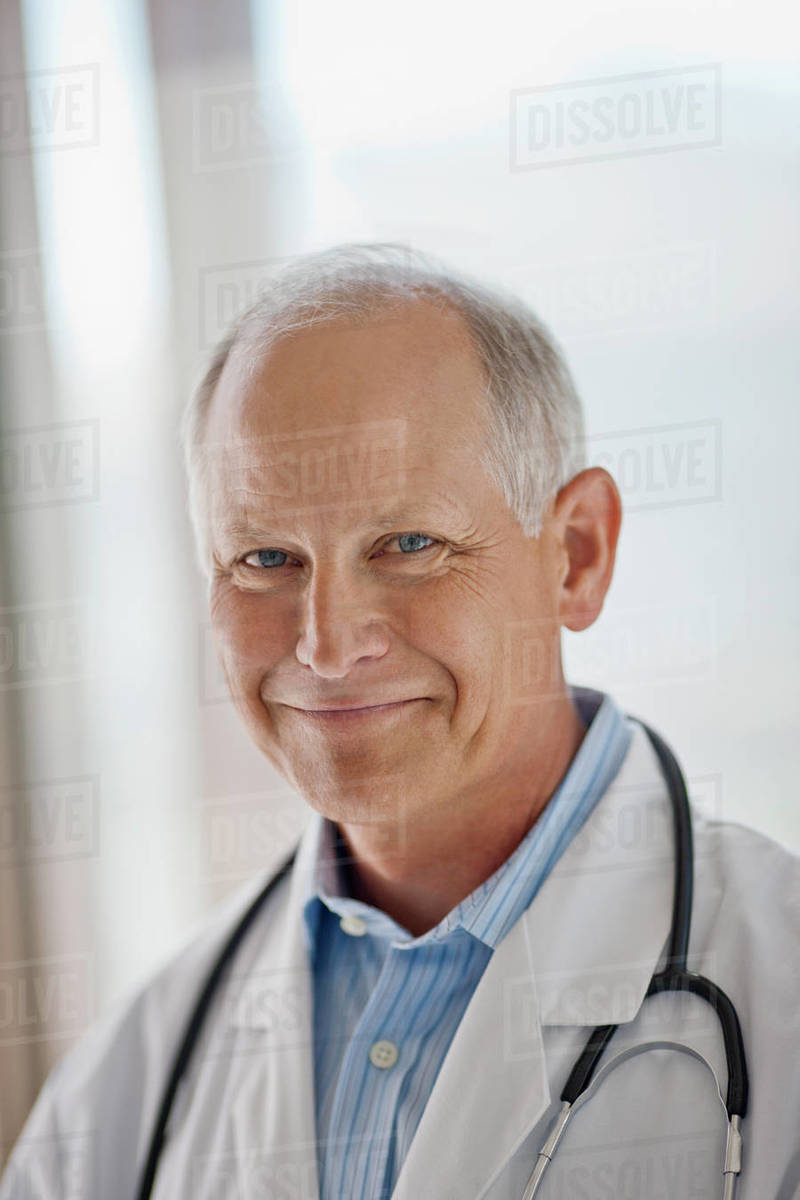 Portrait of a smiling senior doctor with a stethoscope around his neck ...
