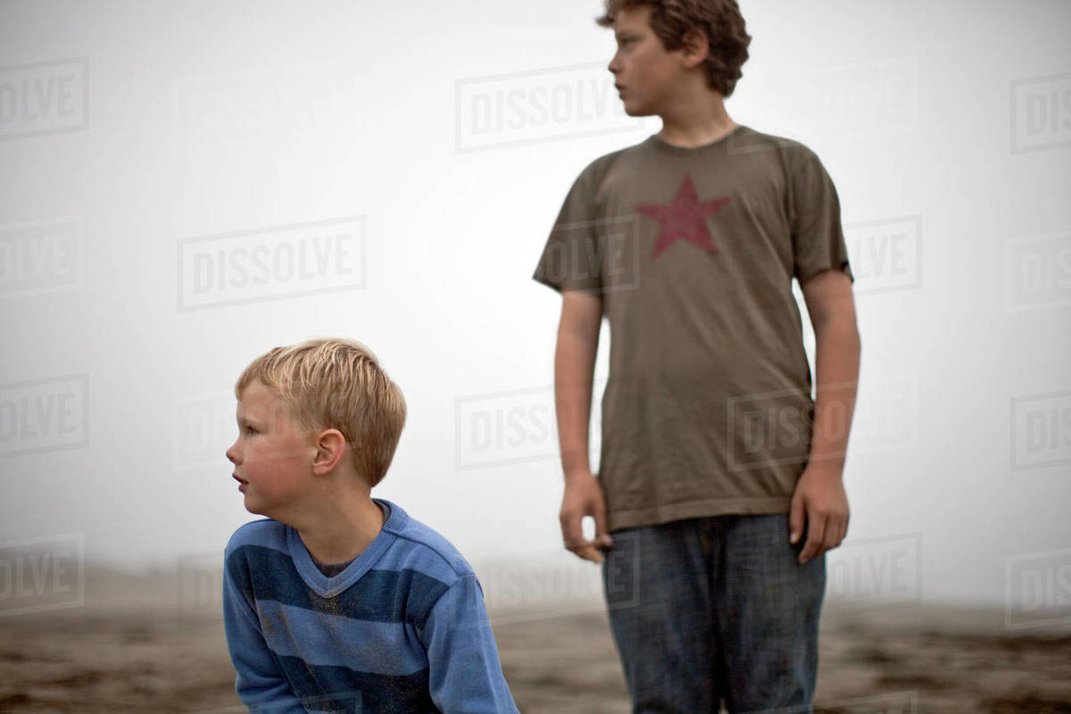 Two brothers standing on beach. - Royalty-free Stock Photo | Dissolve