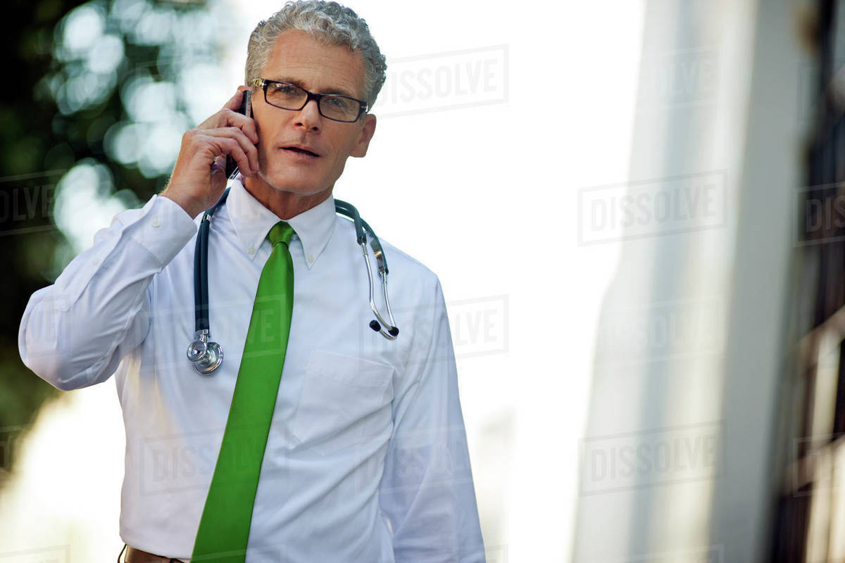 Doctor talking on a cell phone. - Royalty-free Stock Photo | Dissolve