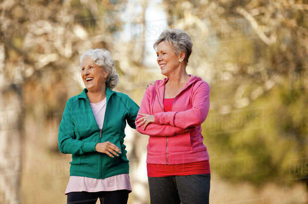 Two laughing senior women standing together in a park. - Royalty-free ...