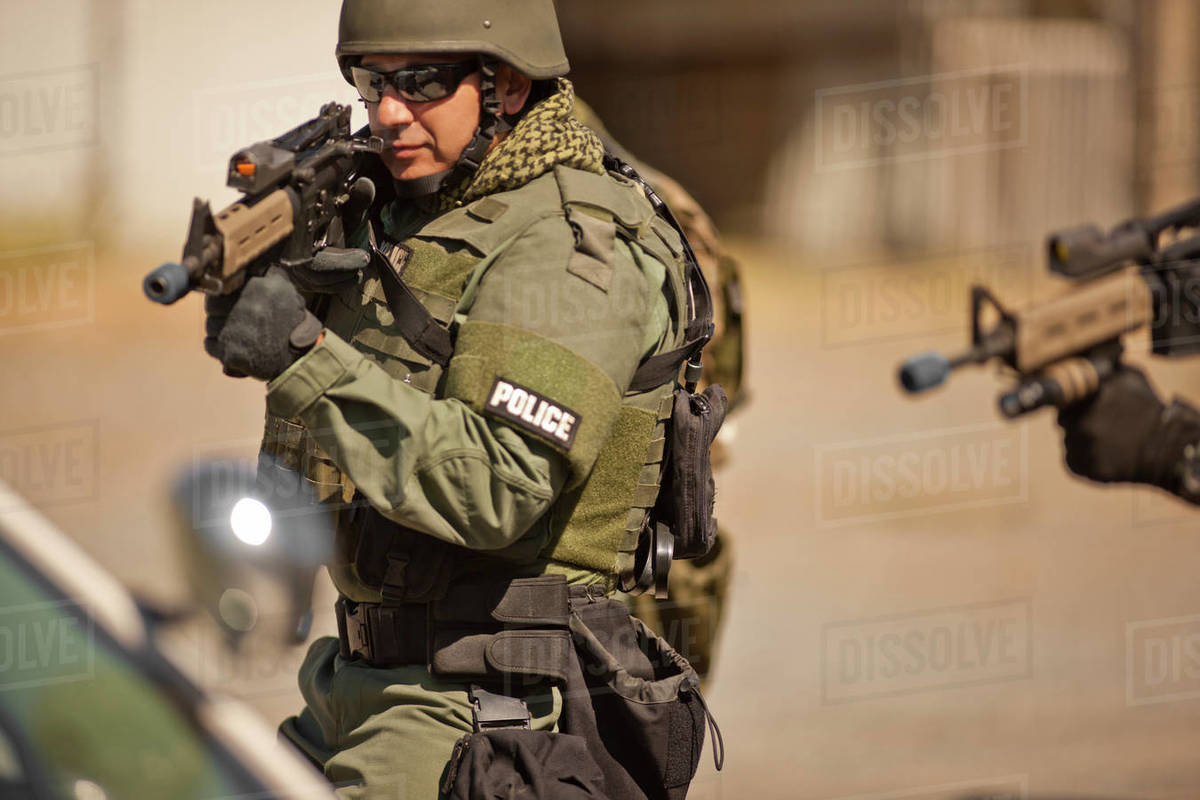 Male police officer aiming a gun toward a target during an exercise at ...