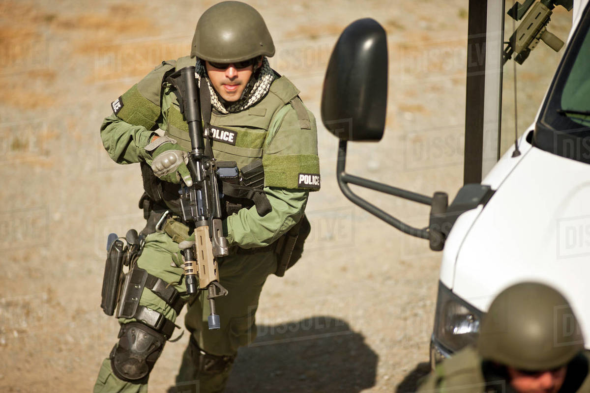 Male police officer aiming a gun toward a target during an exercise at ...