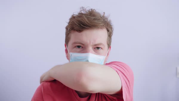 man sneezing,coughing into his arm or elbow to prevent spread Covid-19 ...