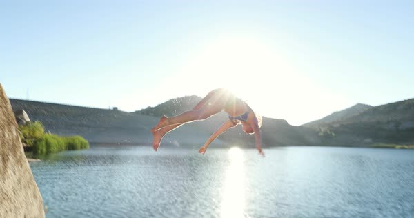 Young woman diving into lake at sunset - 4K Royalty-free Stock Video ...