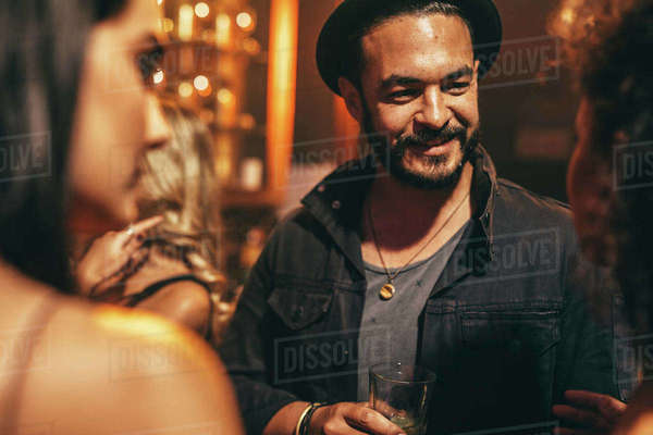 Handsome young man having party with friends at nightclub. Young people ...