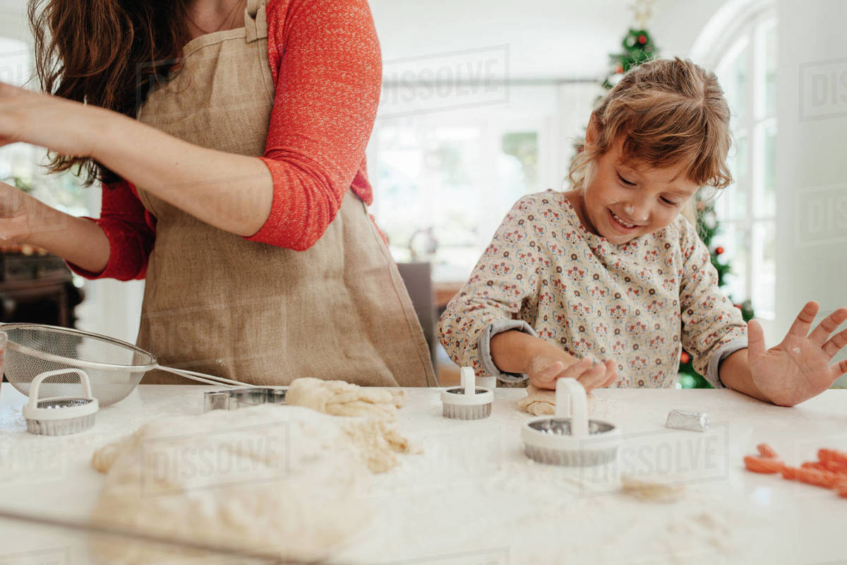 Little girl having fun making cookies. Woman with her daughter making ...