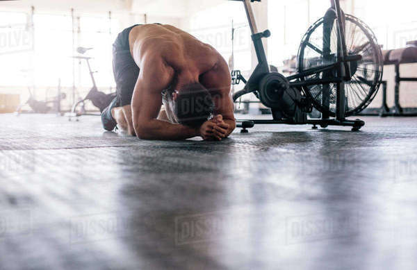Muscular man tired after intense in crossfit gym. Bodybuilder taking ...