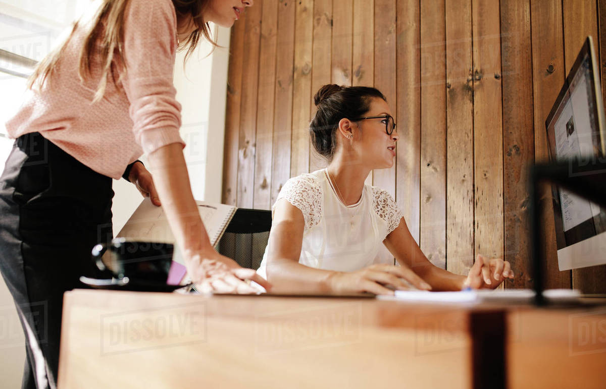 Two business women working together on project at office. Female ...