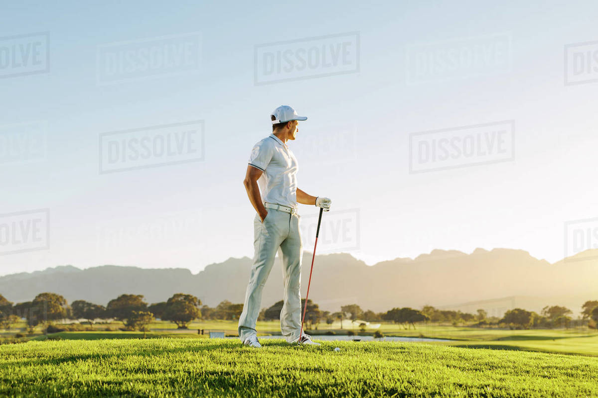Full length of young caucasian man standing on golf course on a summer ...