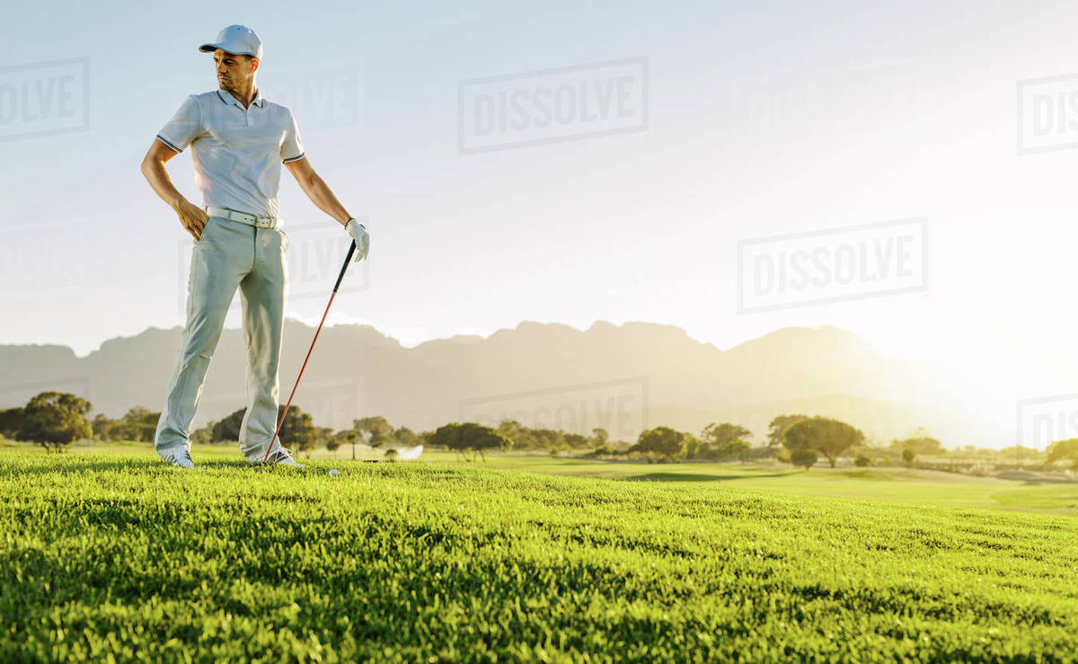 Full length of young male golfer standing on golf course on a summer ...