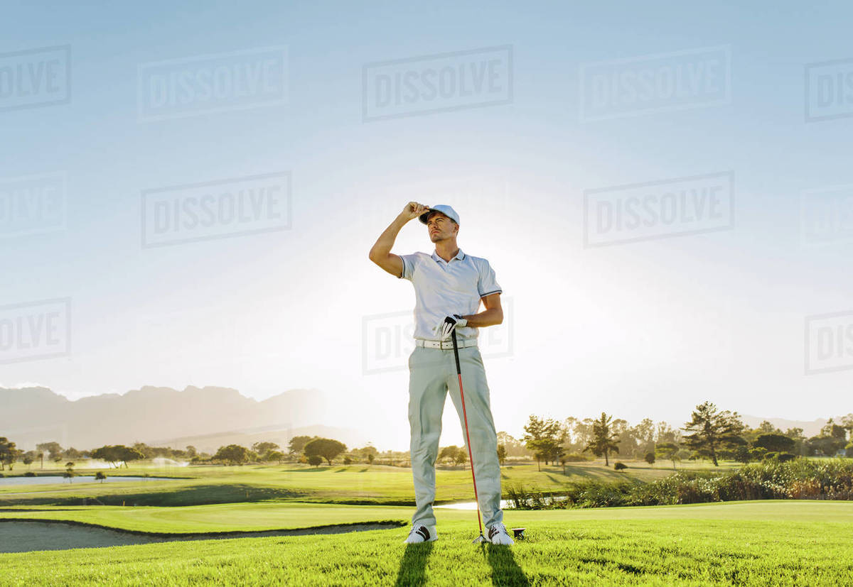 Full length of young caucasian man standing on golf course on a summer ...