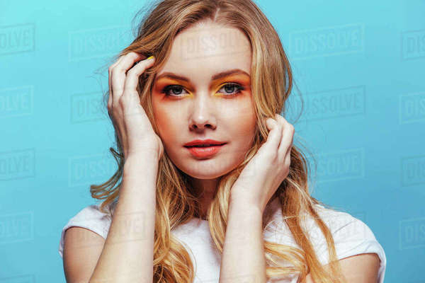 Close up portrait of a beautiful young woman looking at camera with her ...