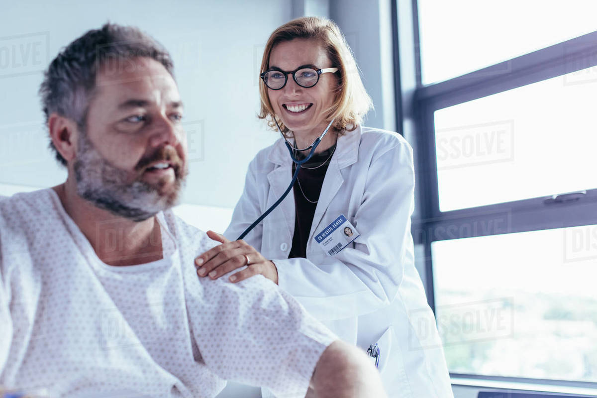 Medical examination of mature male patient in hospital ward. Woman ...