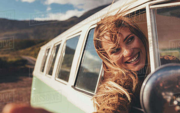 Happy woman on road trip driving a van and laughing. Smiling caucasian ...