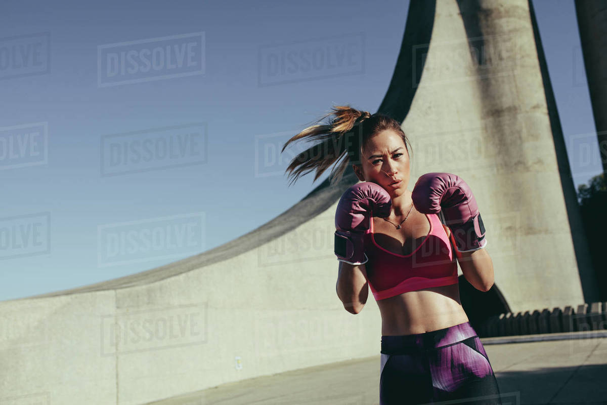 Young muscular woman practicing boxing. Female boxer doing boxing ...